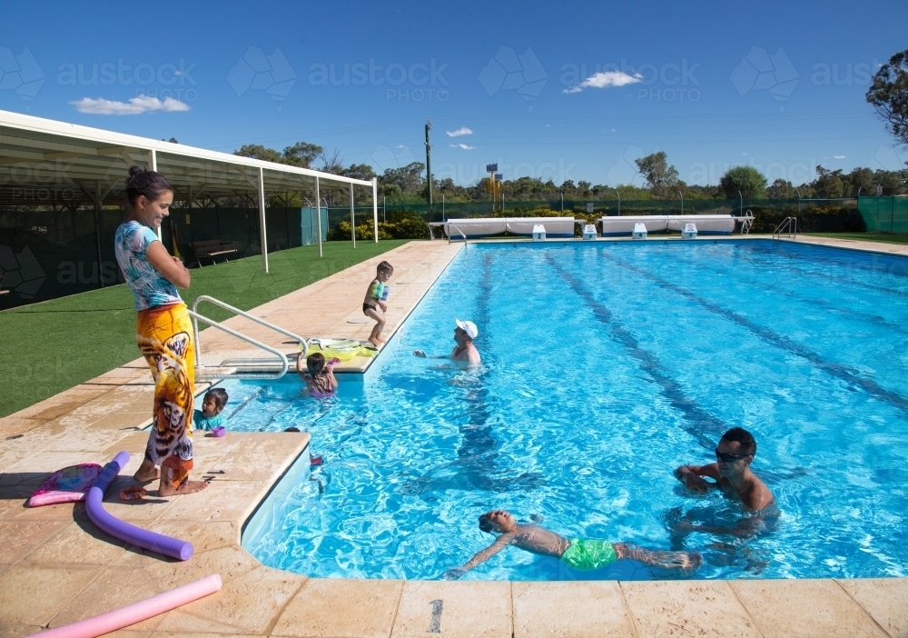 Image of Family with young children in swimming pool - Austockphoto