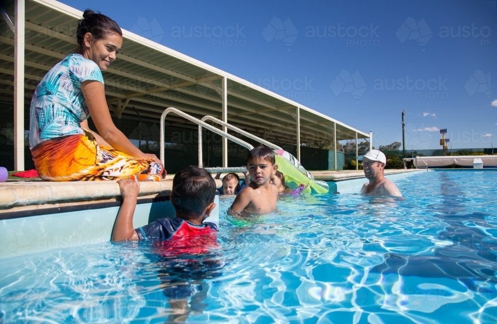 Image of Family with young children in swimming pool - Austockphoto