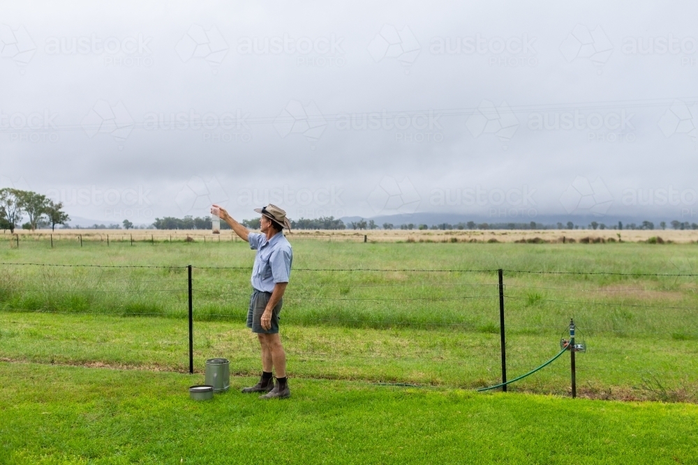 Image of Farmer checking rain measurement on farm after rain storm has ...