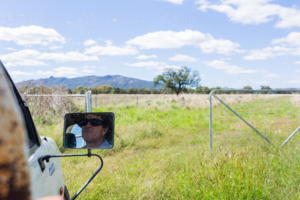 Image of Farmers face reflected in ute side mirror while driving ...