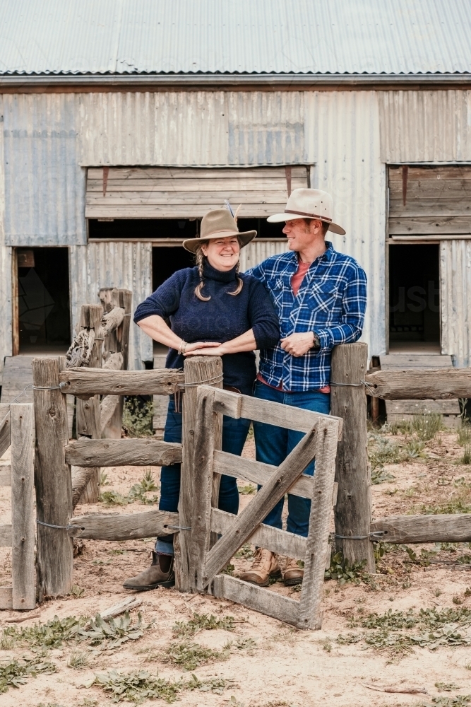 Image of Farming couple smiling in the sheep yards - Austockphoto