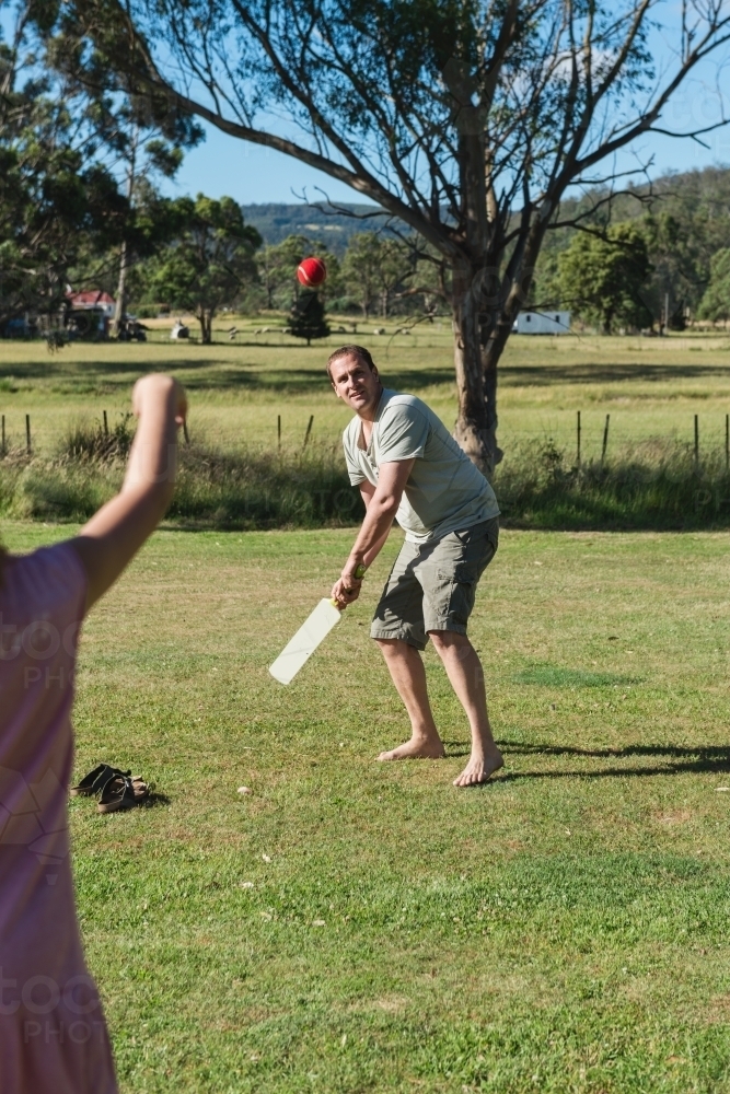 Image of father and daughter playing backyard cricket - Austockphoto