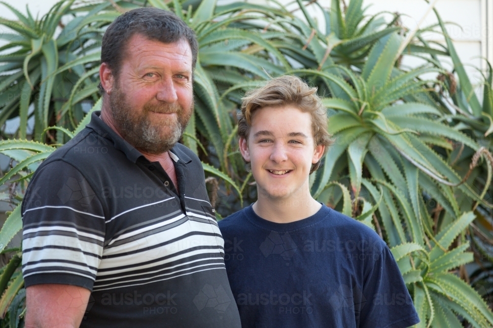 Image of Father and teenage stand son side by side - Austockphoto