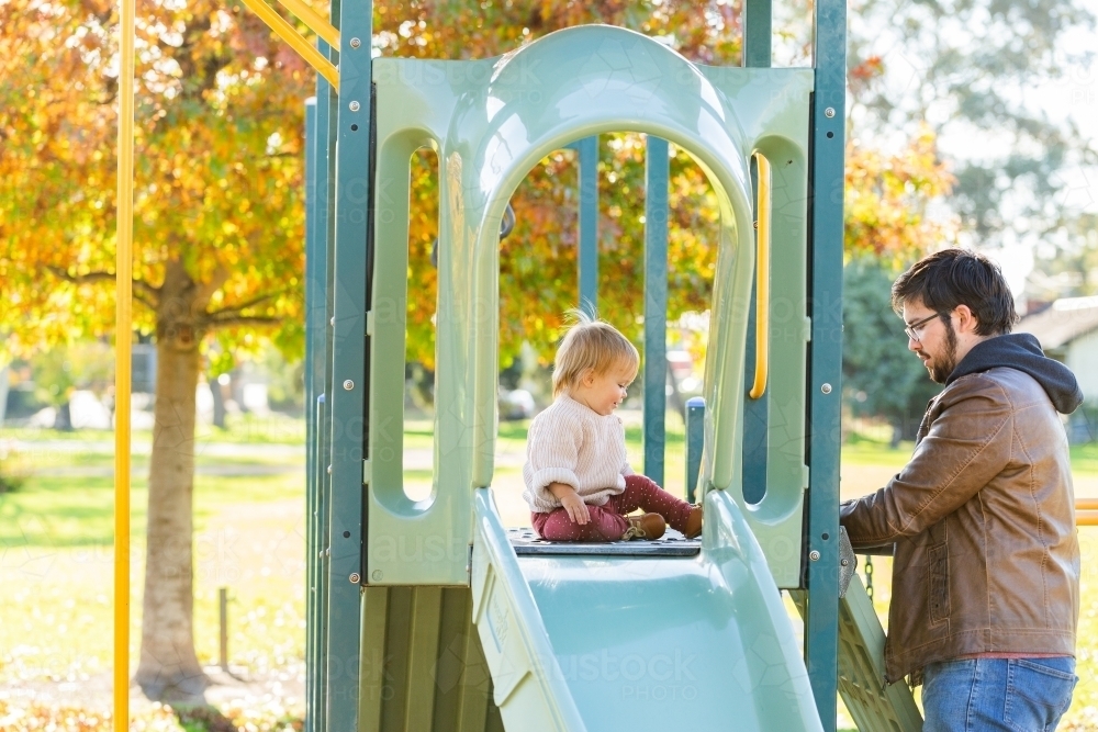 Image of Father and toddler girl playing on park playground in autumn ...