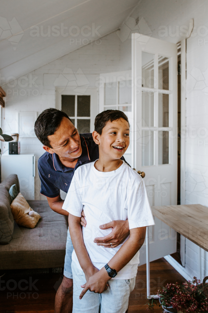 Image of Father hugging his son from the back - Austockphoto