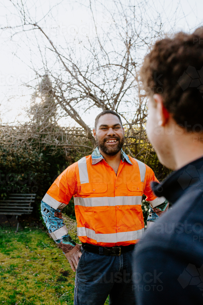Image of Father in high vis clothing having conversation with teenage ...