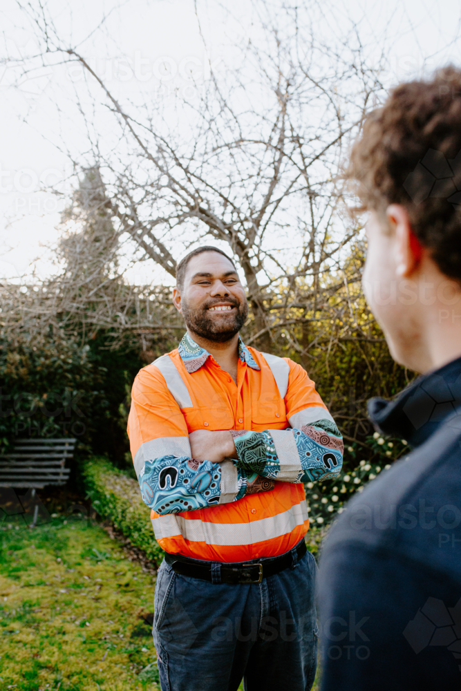 Image of Father in high vis clothing having conversation with teenage ...