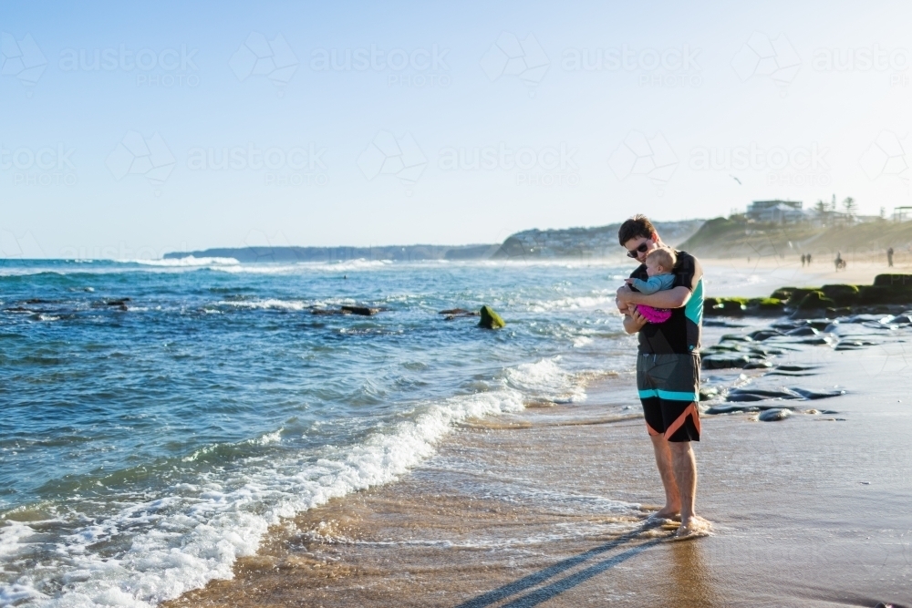 Image of Father showing young baby the ocean for the first time sanding ...