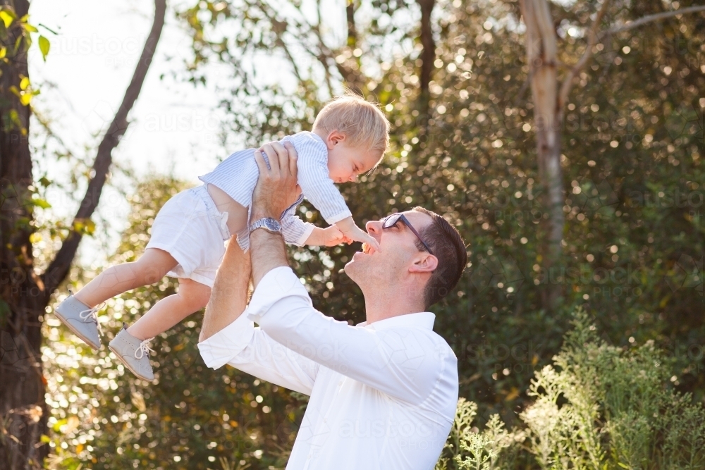 Image of Father throwing son in the air playing together outside ...