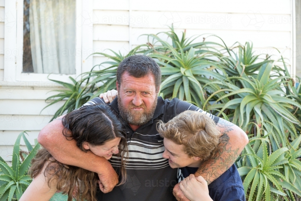 Image of Father with his teenage kids in headlocks - Austockphoto