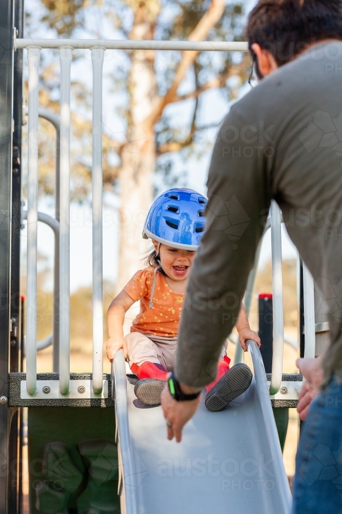 Image of Father with little kid sliding down slide at park playground ...