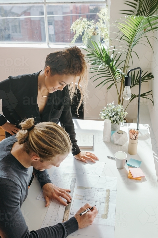 Image of Female boss looking at a young architect's work - Austockphoto