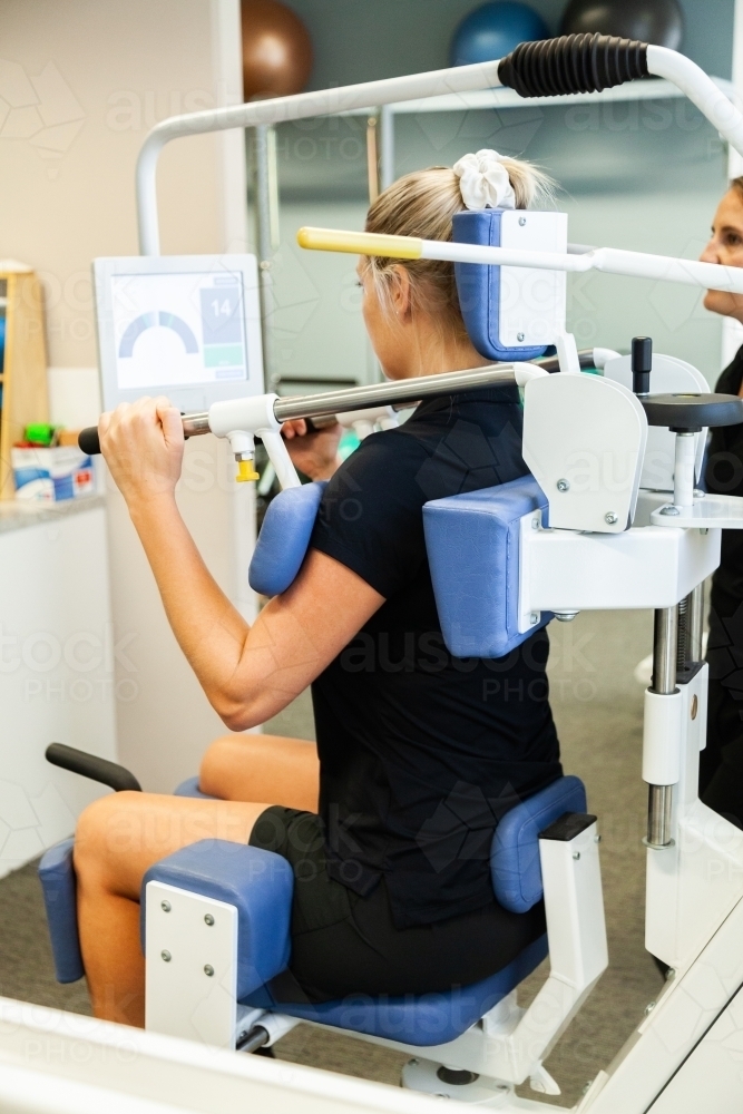 Image of Female client using rehabilitation exercise machine at ...