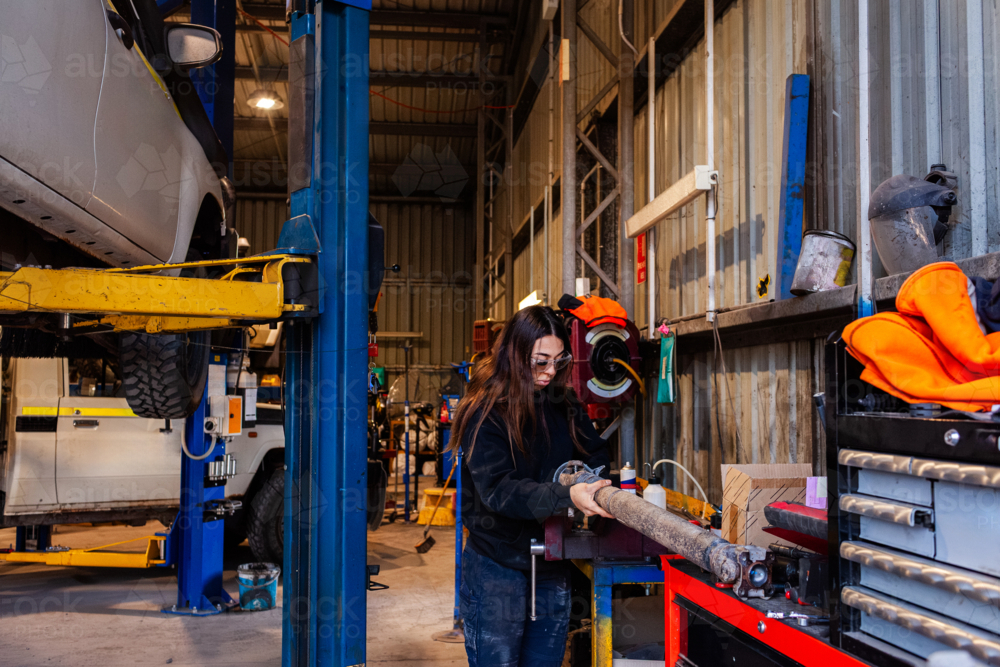 Image of Female mechanic checking and repairing vehicle drive shaft in ...