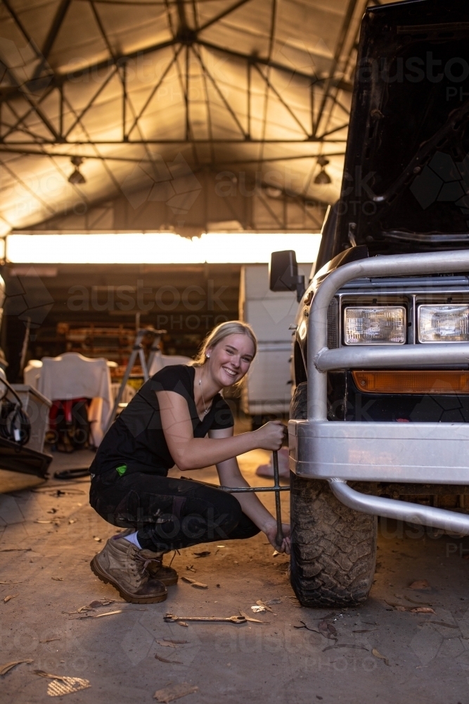 Image of Female mechanic working on car tyres in an auto garage ...