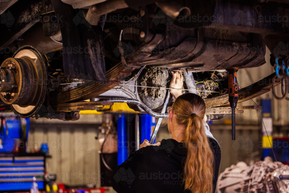 Image of Female mechanic working on differential axel component ...