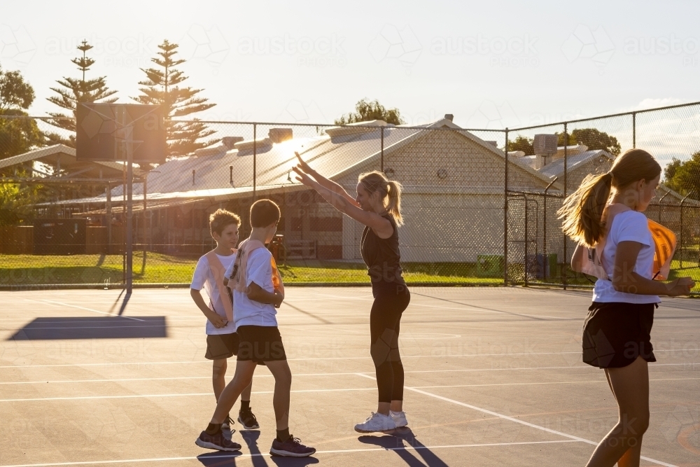 Image of female teacher demonstrating defending position to children on ...