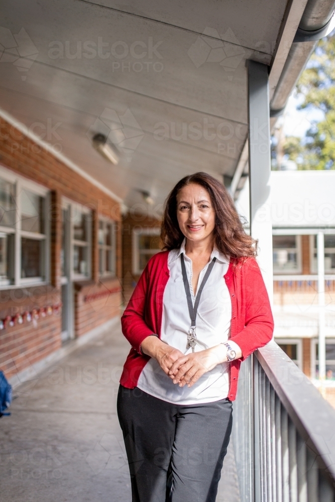 Image of Female Teacher Standing on school Balcony Smiling at Camera ...
