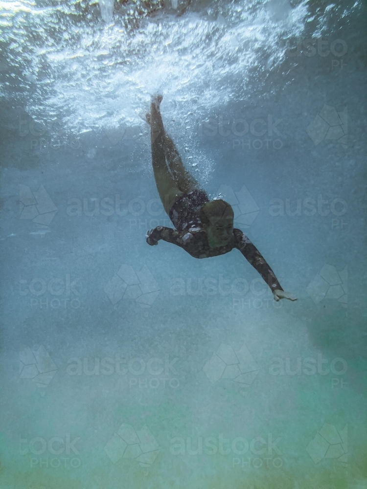 Image of Female underwater in ocean wearing full piece swimsuit ...