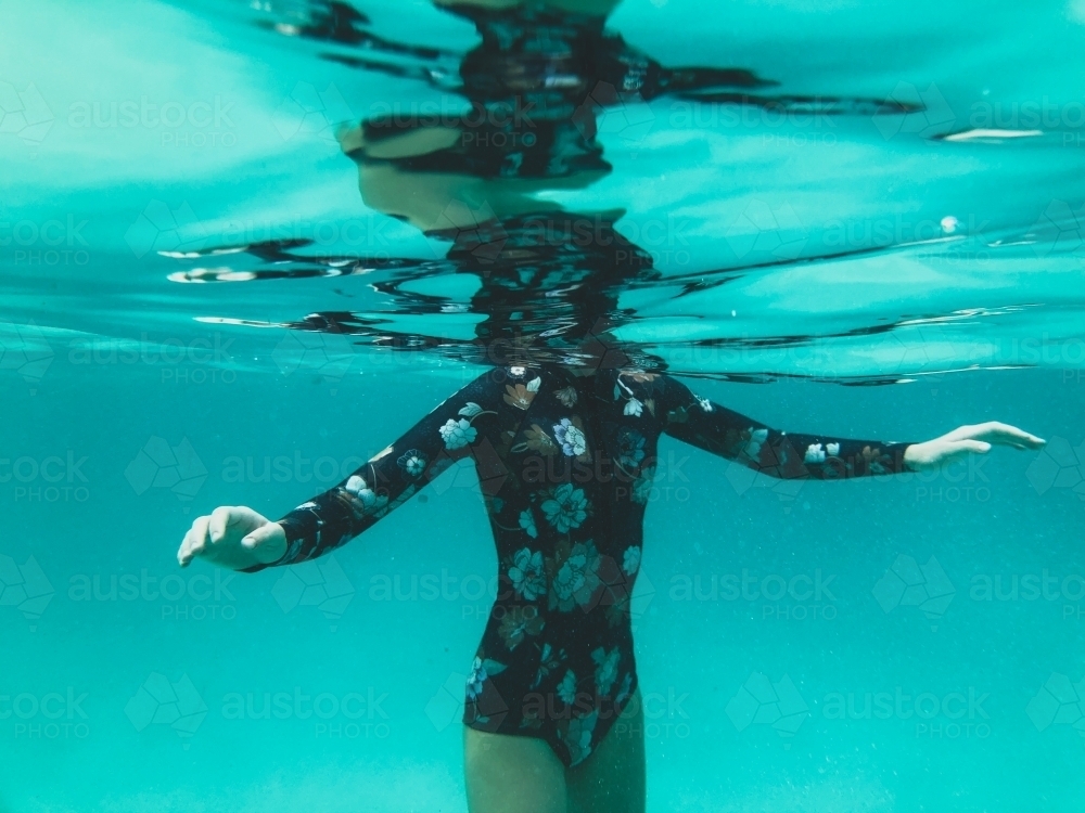 Image of Female underwater in ocean wearing full piece swimsuit ...