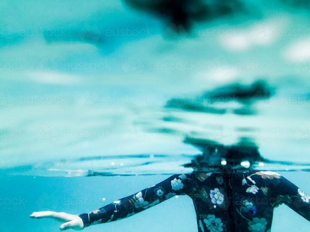 Image of Female underwater in ocean wearing full piece swimsuit ...