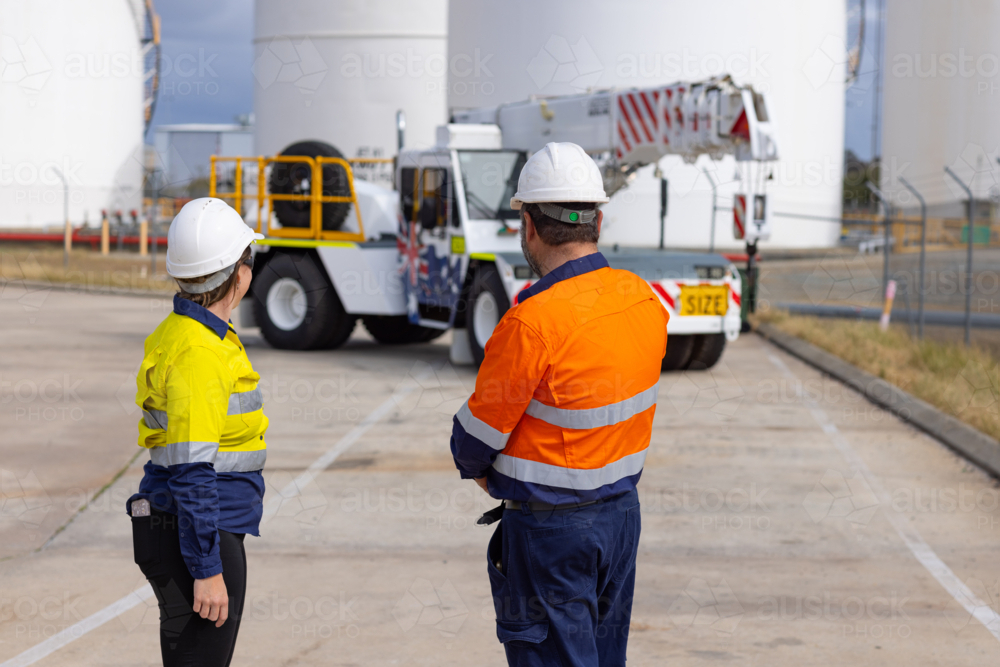 Image of Female worker talking with male employee at industrial site ...