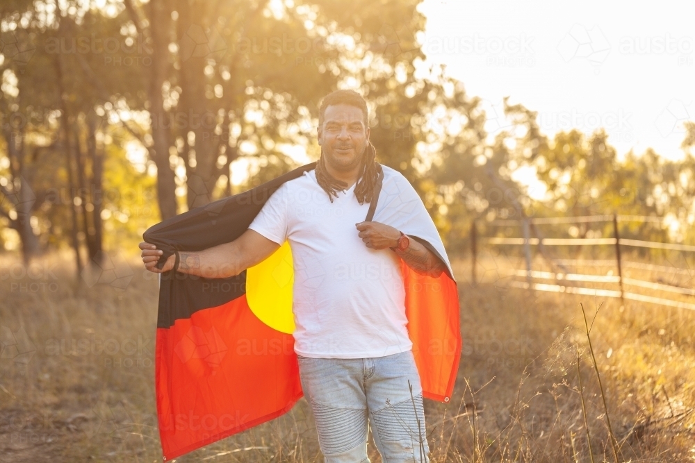 Image of First Nation Australian man standing with Aboriginal flag in ...