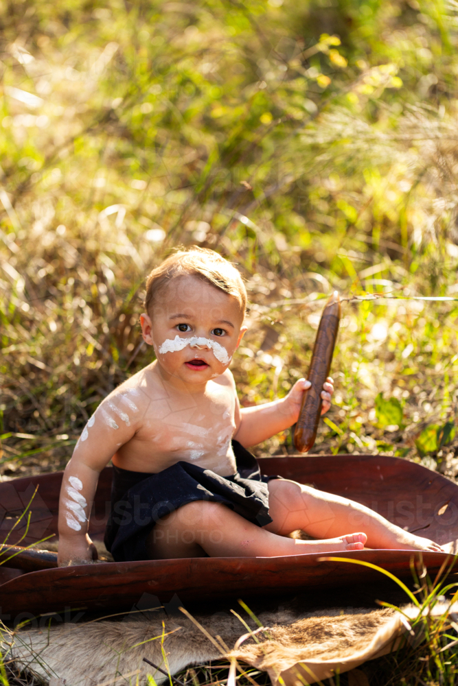 Image of First Nations Australian boy in coolamon among grass in ...