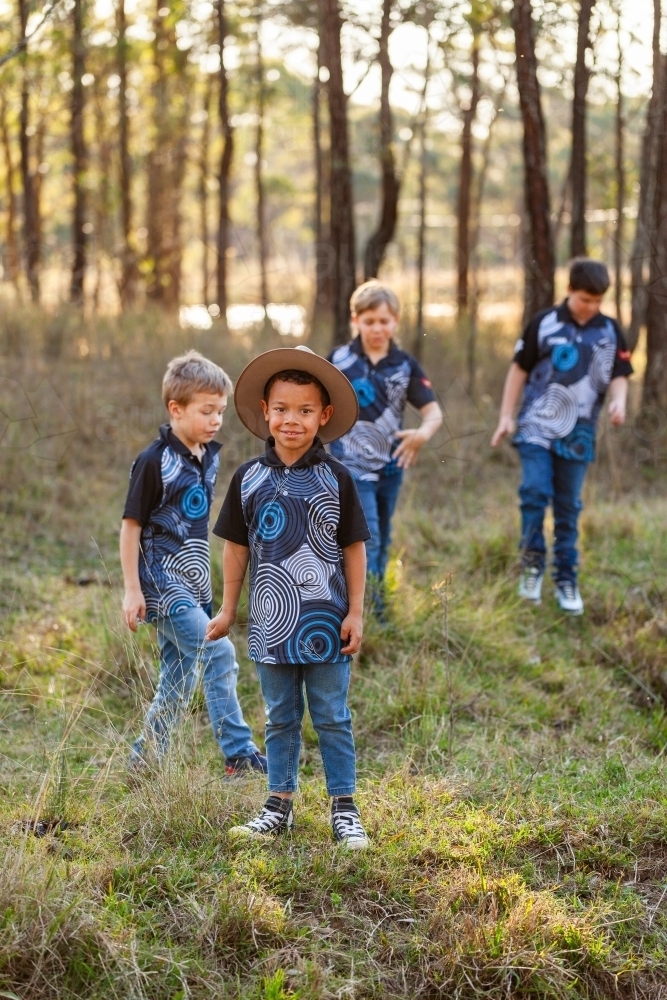 Image of First nations Australian boys playing in bushland - Austockphoto