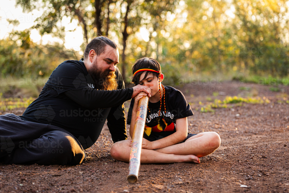 Image of First Nations Australian father teaching Aboriginal son to ...