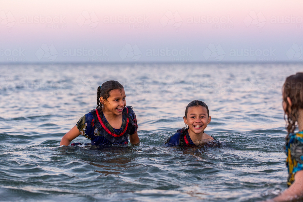 Image of First Nations Australian girls playing in ocean water after ...