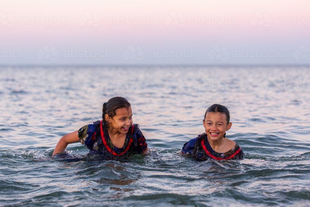 Image of First Nations Australian girls playing in ocean water after ...