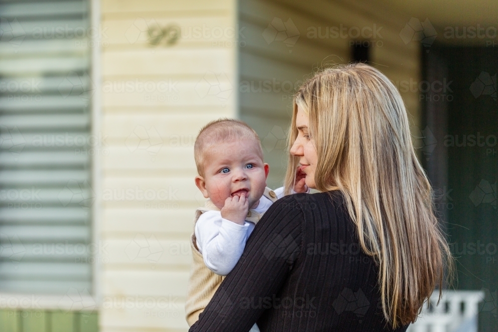 Image of First Nations Australian mum and baby outside home - Austockphoto