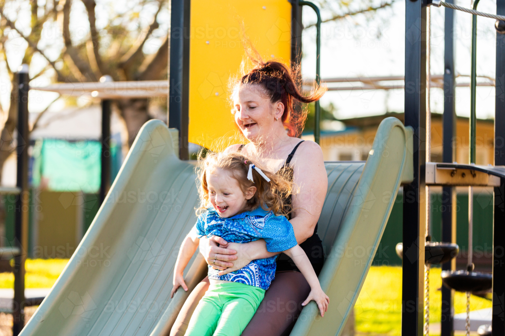 Image of First Nations Australian Mum and daughter sliding down slide ...