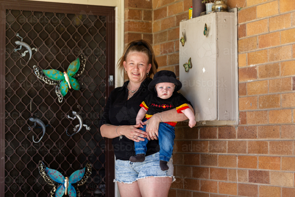 Image of First Nations Australian mum standing by front door of home ...
