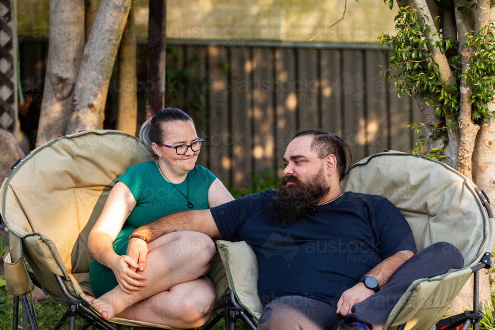 Image of First Nations Australian parents relaxing together in chairs ...