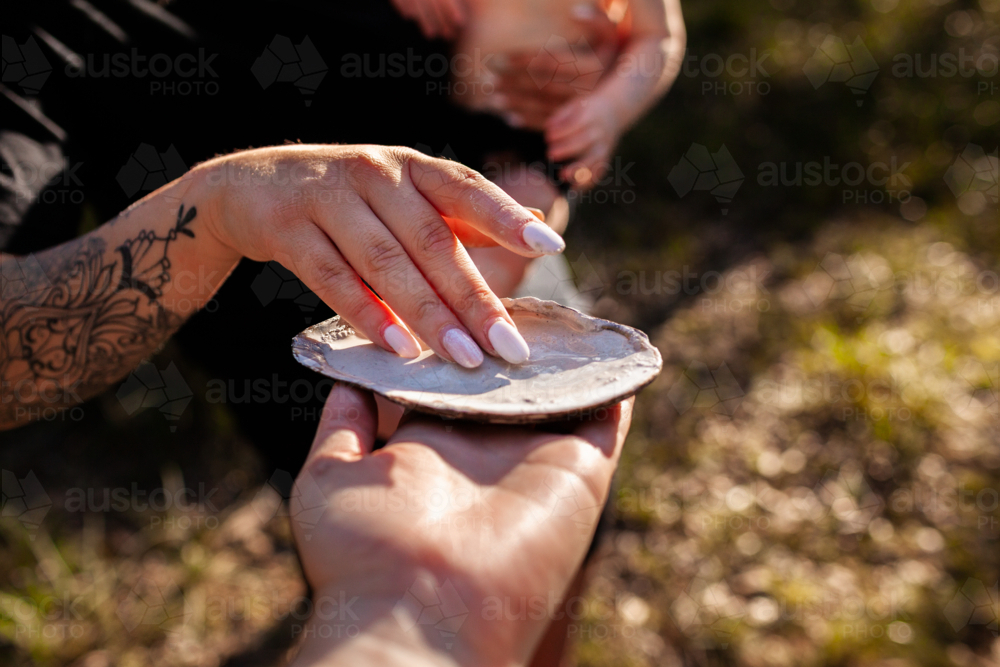 Image of First Nations Australian woman dipping fingers into ochre body ...