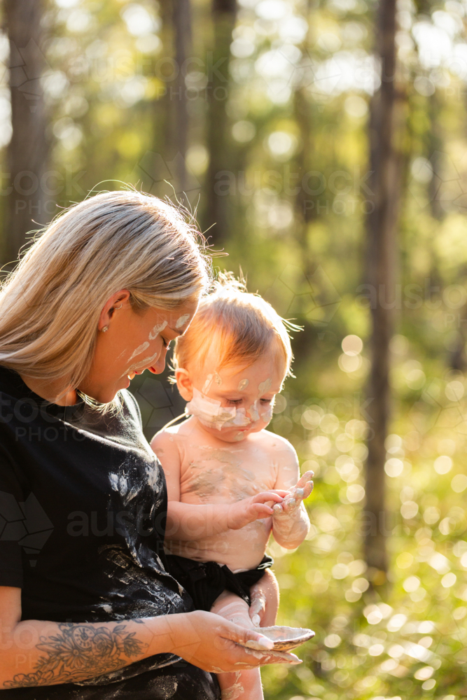 Image of First Nations Australian woman with baby boy applying cultural ...