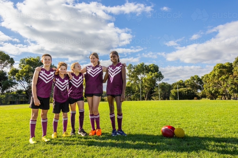 Image of five members of a kids' football team standing on green ...