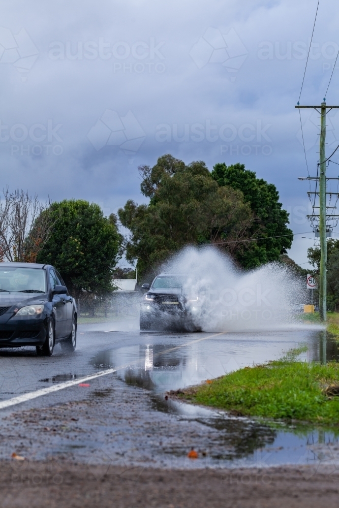 Image of Flood water forming puddle on highway road through town with ...