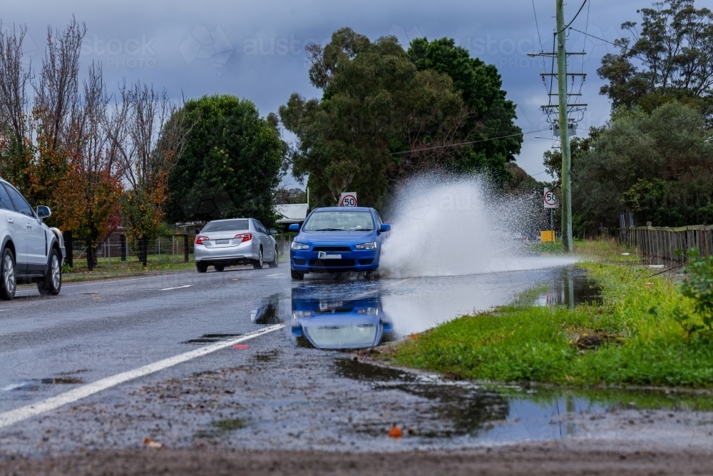 Image of Flood water forming puddle on highway road through town with ...