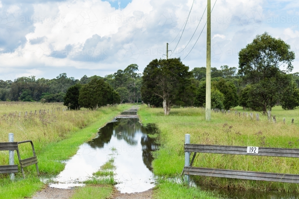 Image of Flooded rural driveway entrance with water flowing over ...