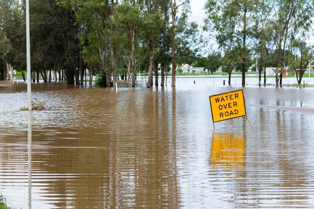 Image of Floodwater rising over water over road sign on highway ...