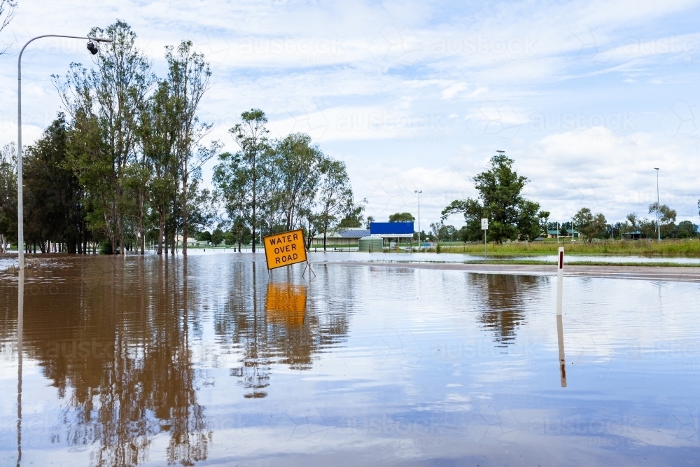 Image of Floodwater rising over water over road sign on highway ...