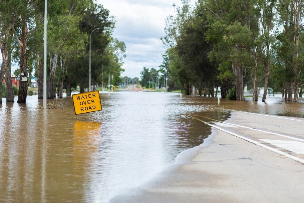 Image of Floodwater rising over water over road sign on highway ...