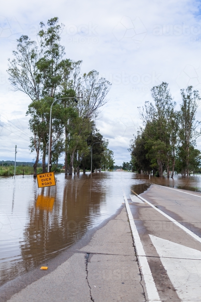 Image of Floodwater rising over water over road sign on highway ...