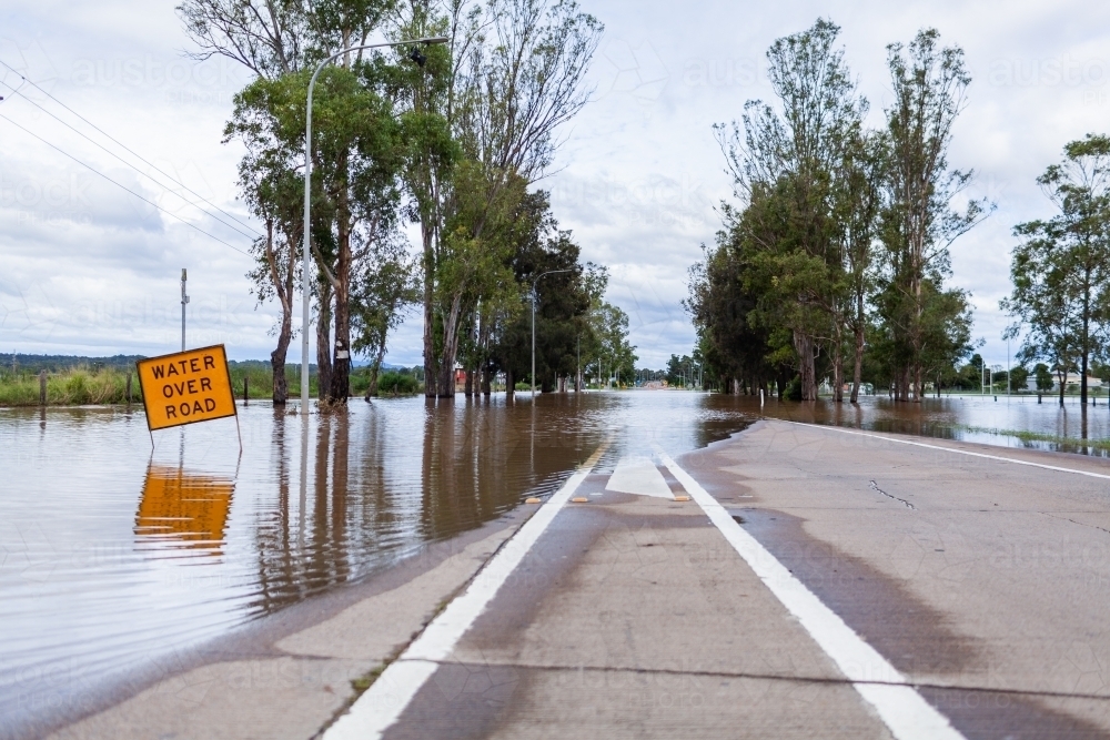 Image of Floodwater rising over water over road sign on highway ...
