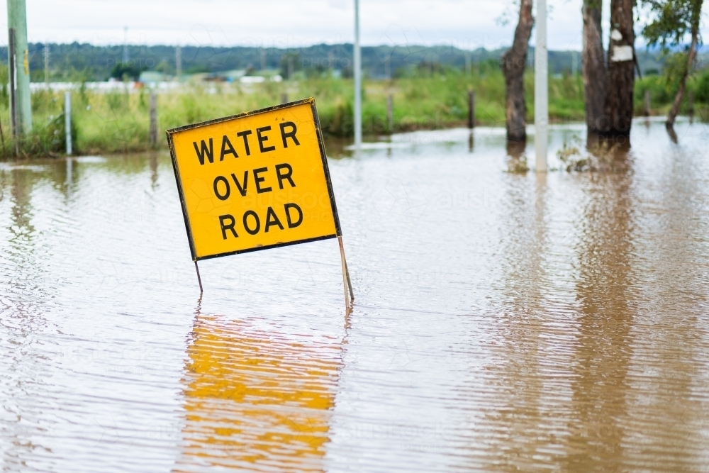Image of Floodwater rising over water over road sign on highway ...