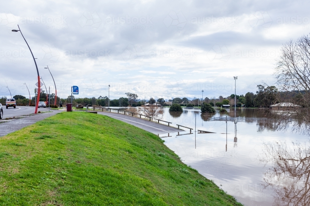 Image of Floodwater rising up levee bank towards town during natural ...
