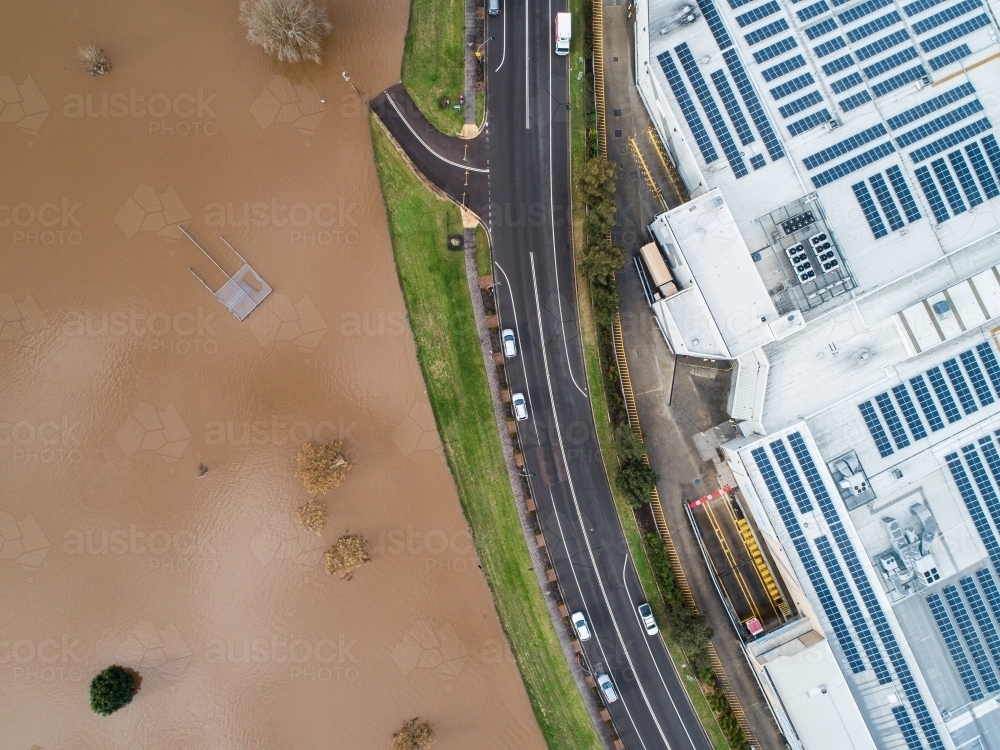 Image of floodwaters covering riverside park beside township rising up ...